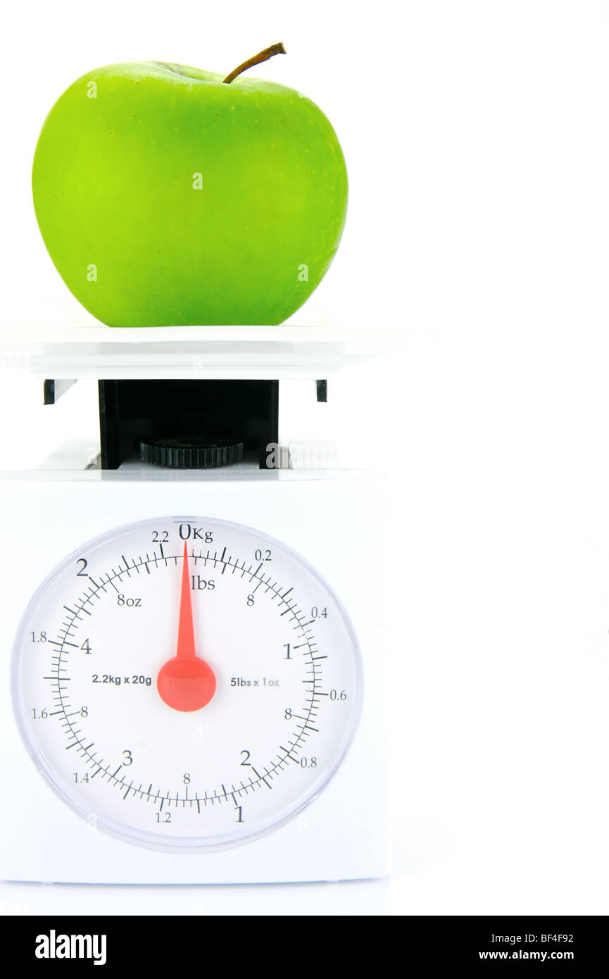 An apple and a set of scales isolated against a white background Stock ...