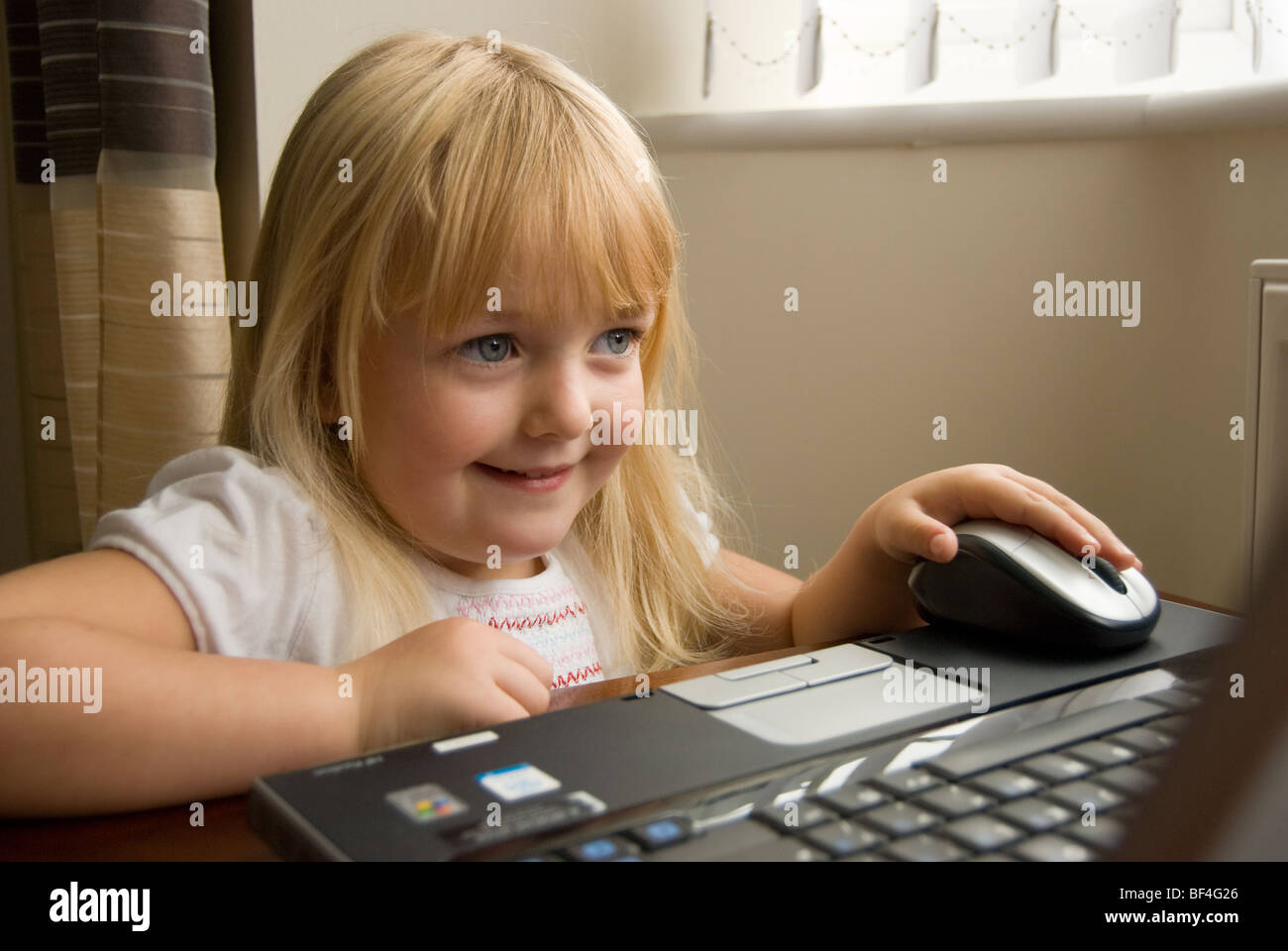 Little girl using a laptop Stock Photo - Alamy