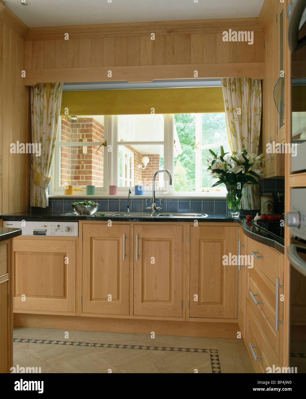 Cream blind on window above dishwasher in pale wood fitted unit in ...