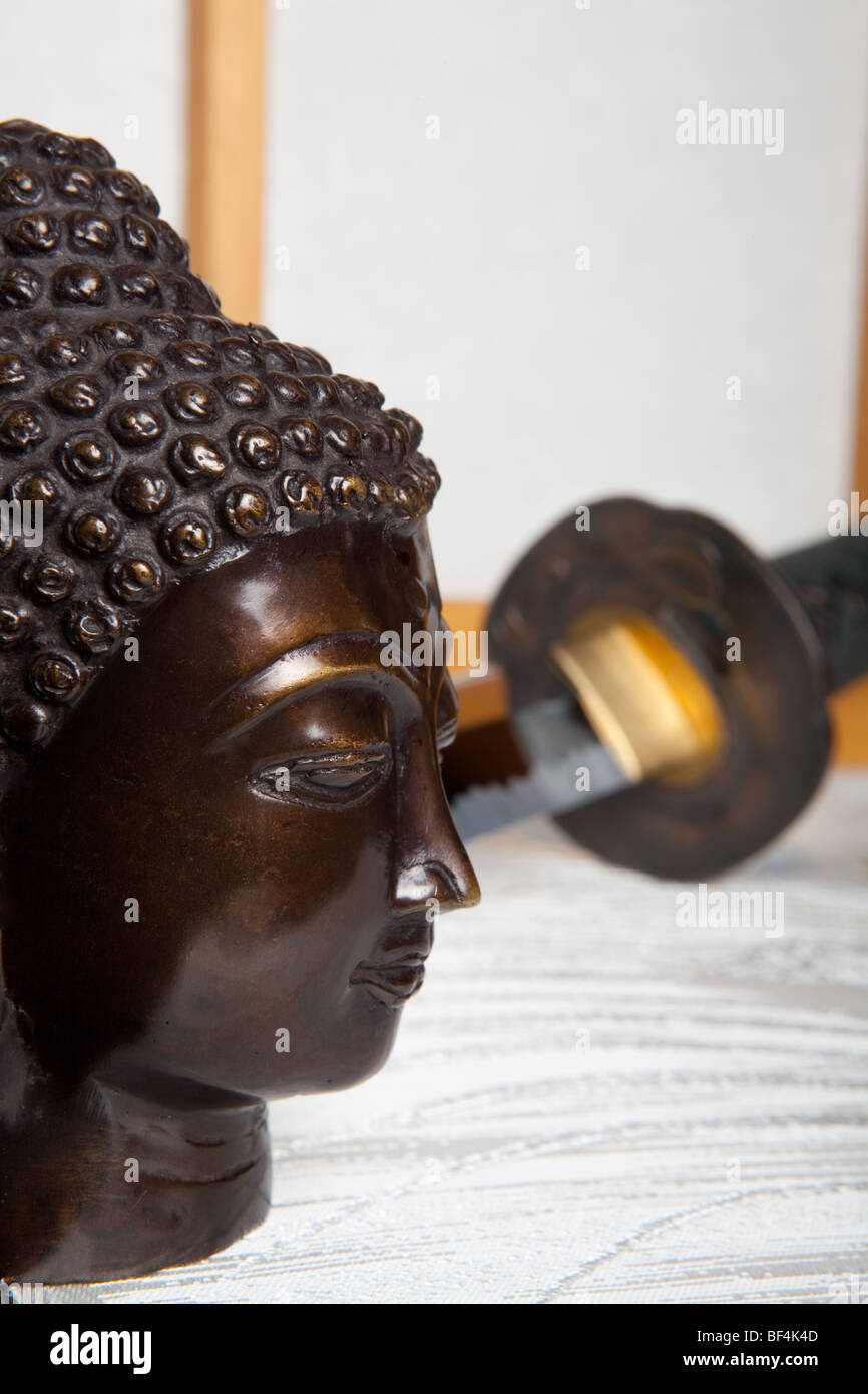 War and peace symbolized by a buddha statue and a japanese samurai ...