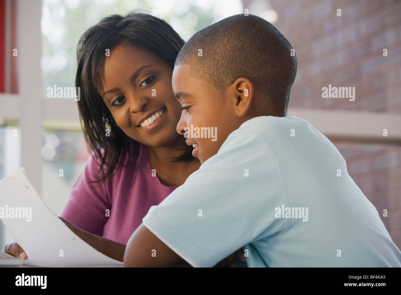 Teacher helping student with homework Stock Photo - Alamy