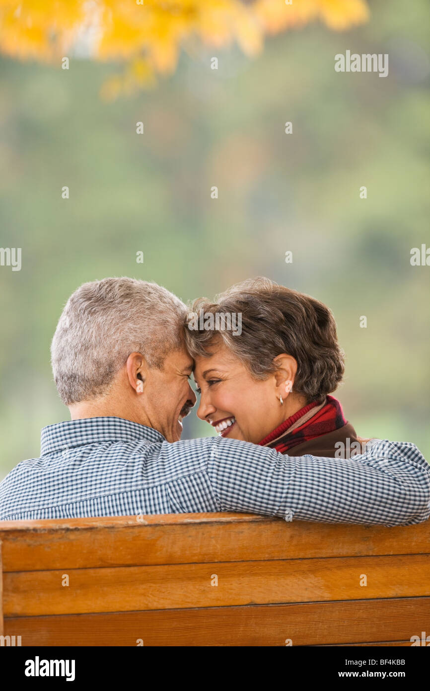 African couple hugging on park bench Stock Photo - Alamy