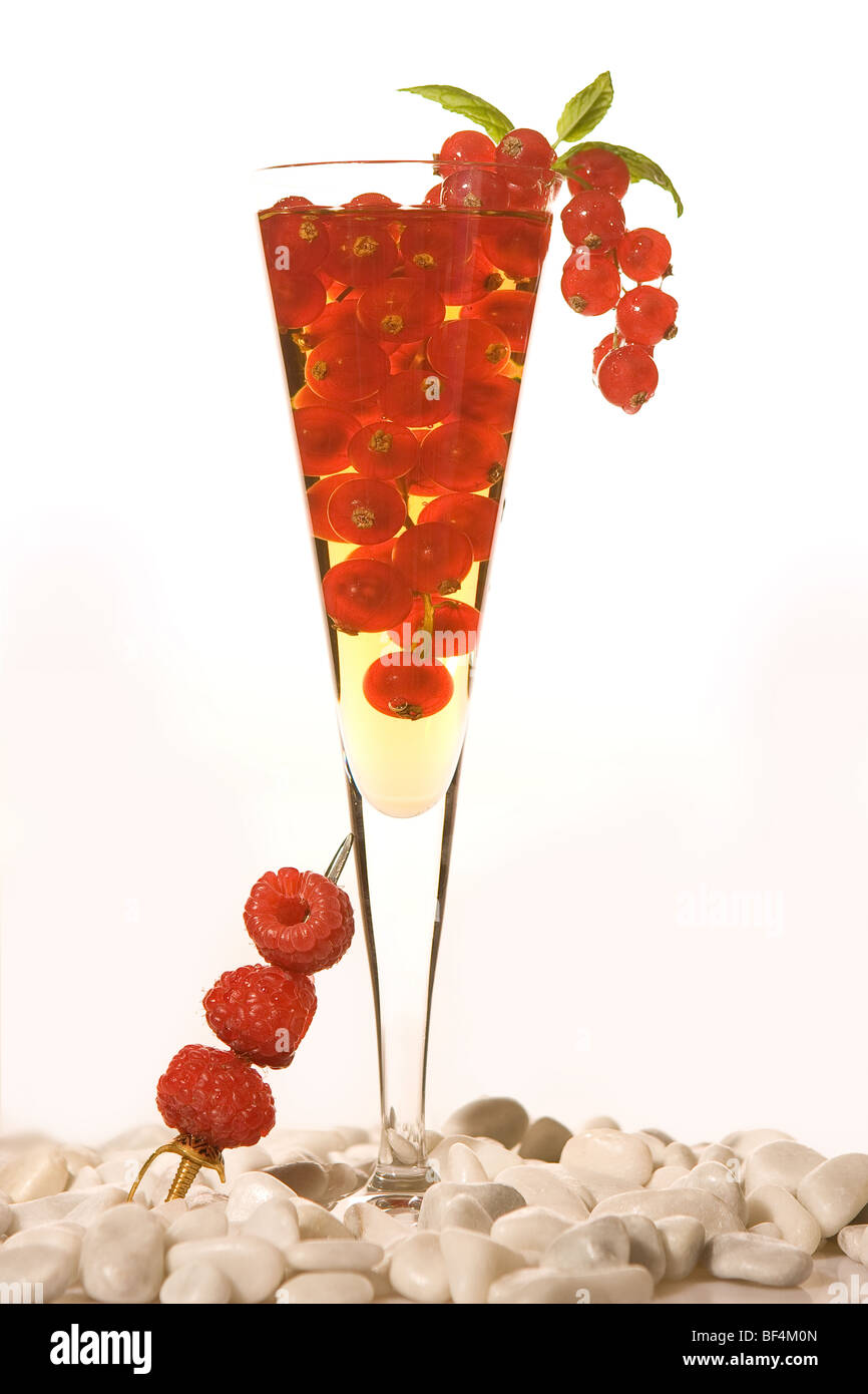 Golden cocktail filled with red berries and raspberries Stock Photo - Alamy