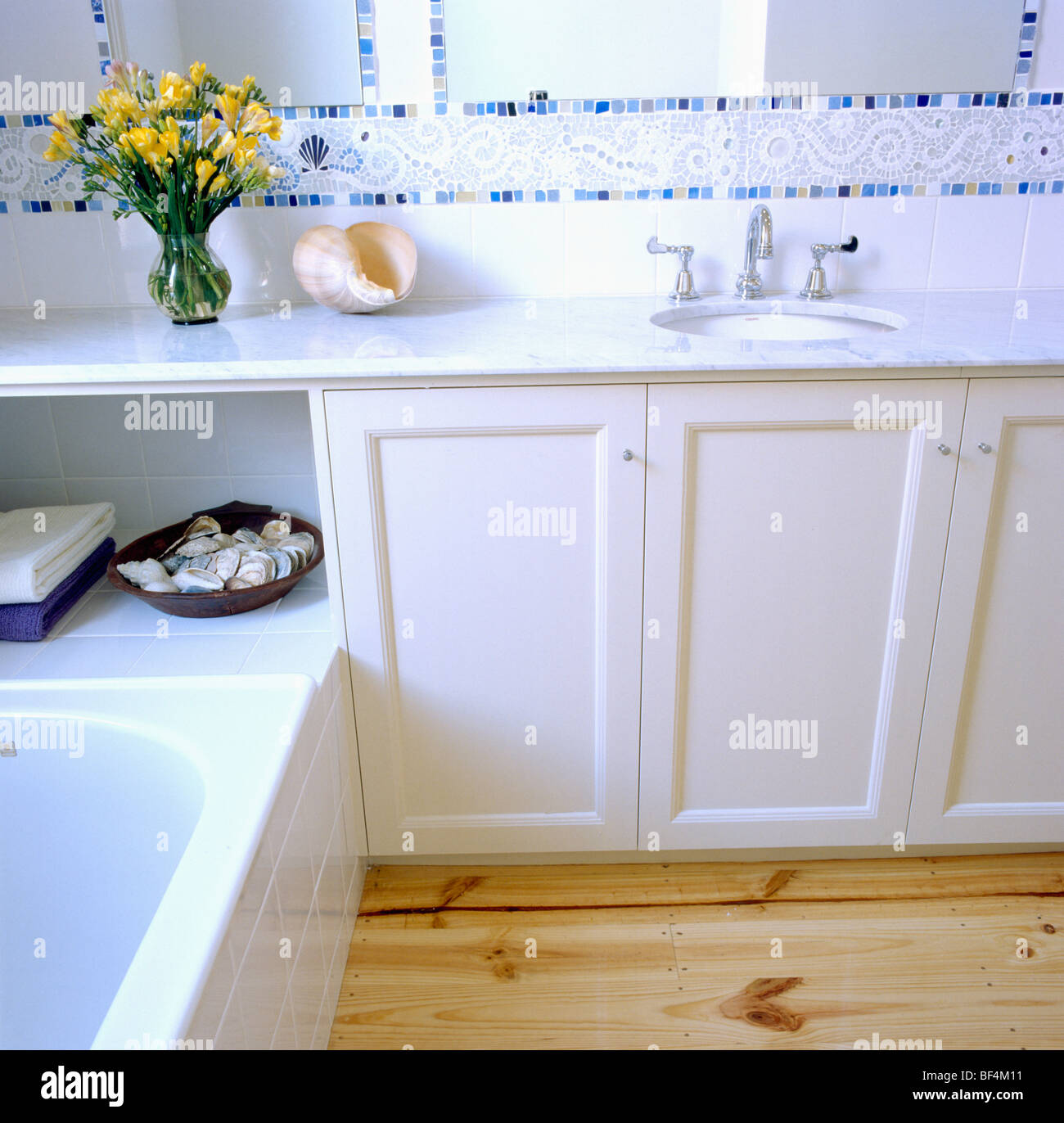 Mosaic tiled border above fitted vanity unit in modern white bathroom ...