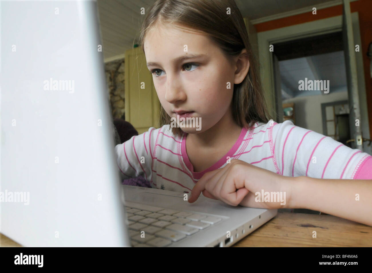 A 9year old girl at the computer in the kitchen Stock Photo - Alamy