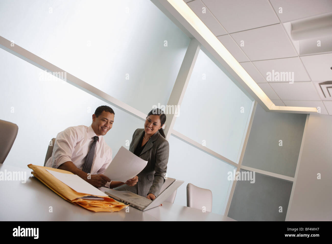Multi-ethnic businesspeople looking at paperwork Stock Photo - Alamy