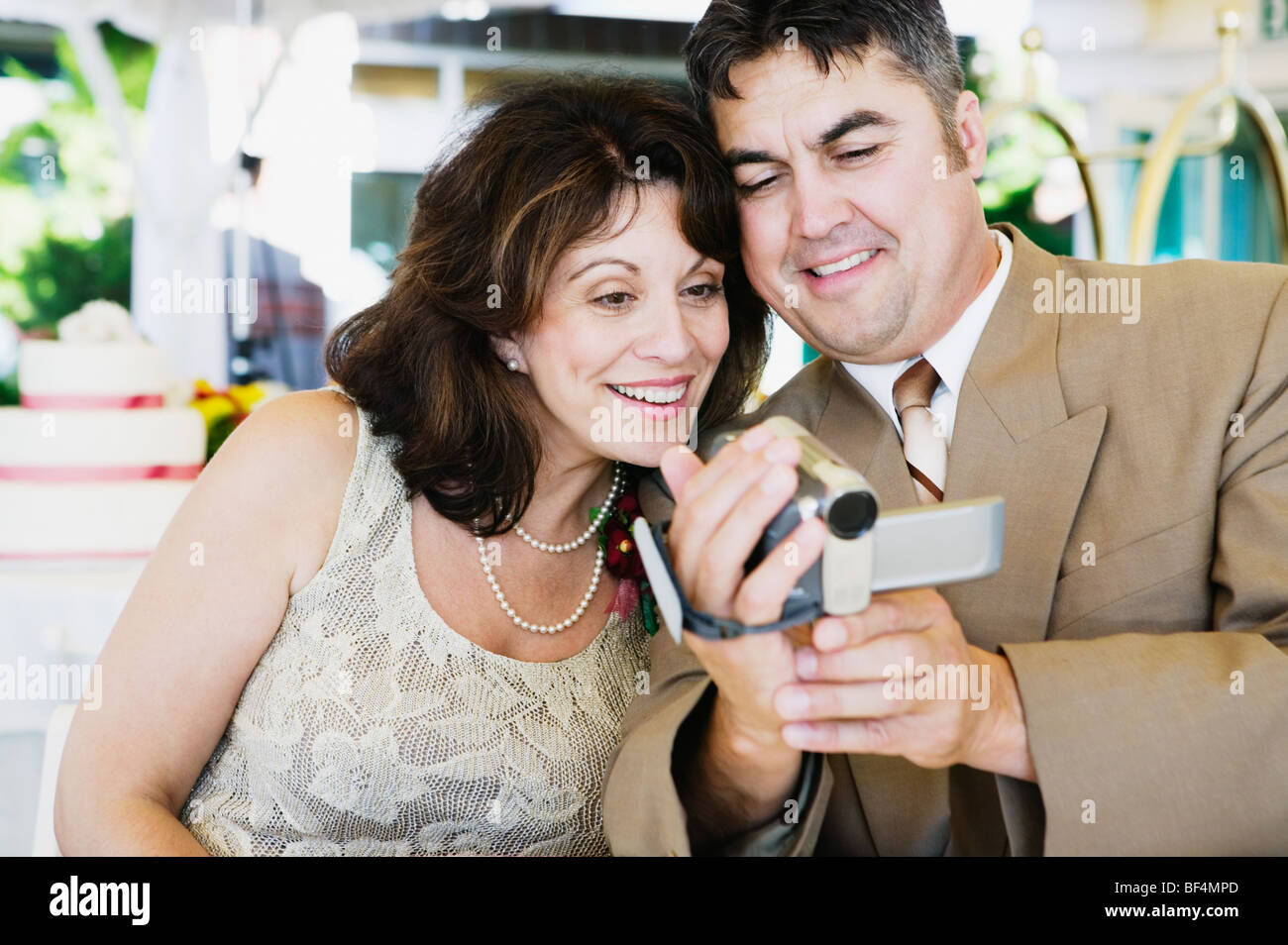 Couple looking at video recorder at wedding Stock Photo - Alamy