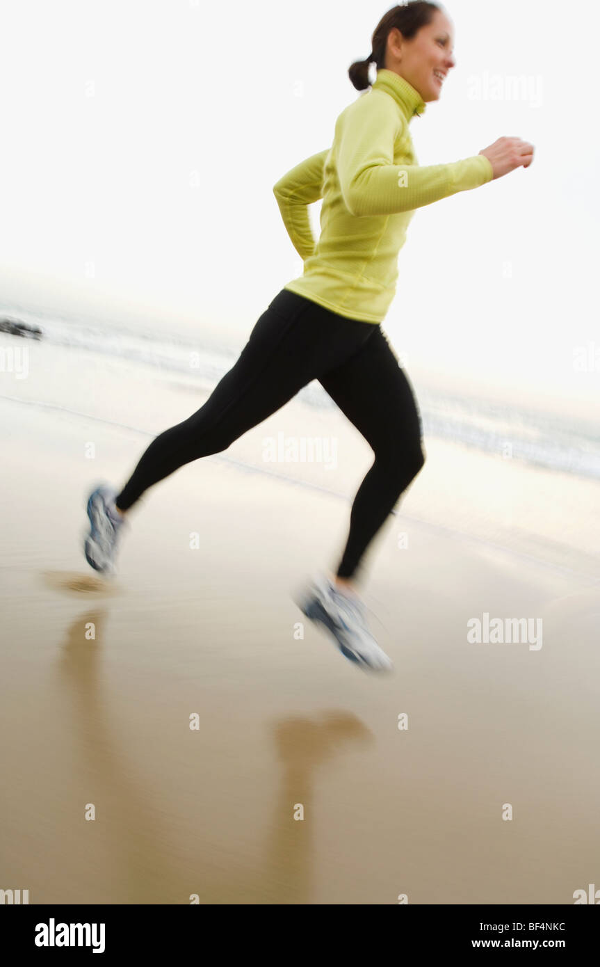 Hispanic woman running on beach Stock Photo - Alamy