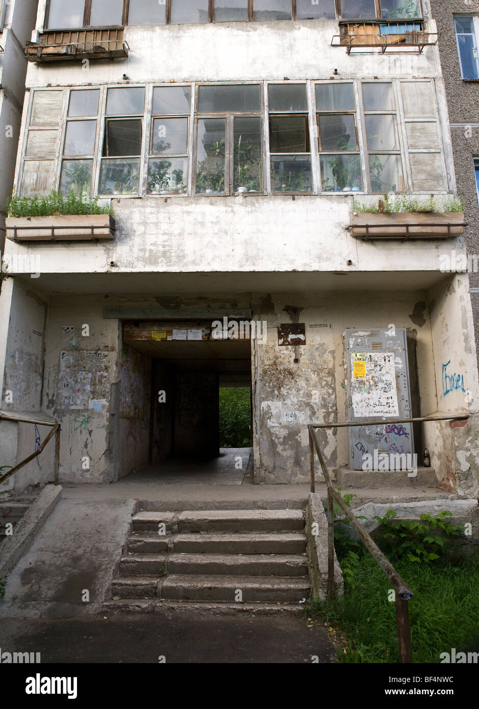 Neglected apartment building exterior with window boxes and plants ...