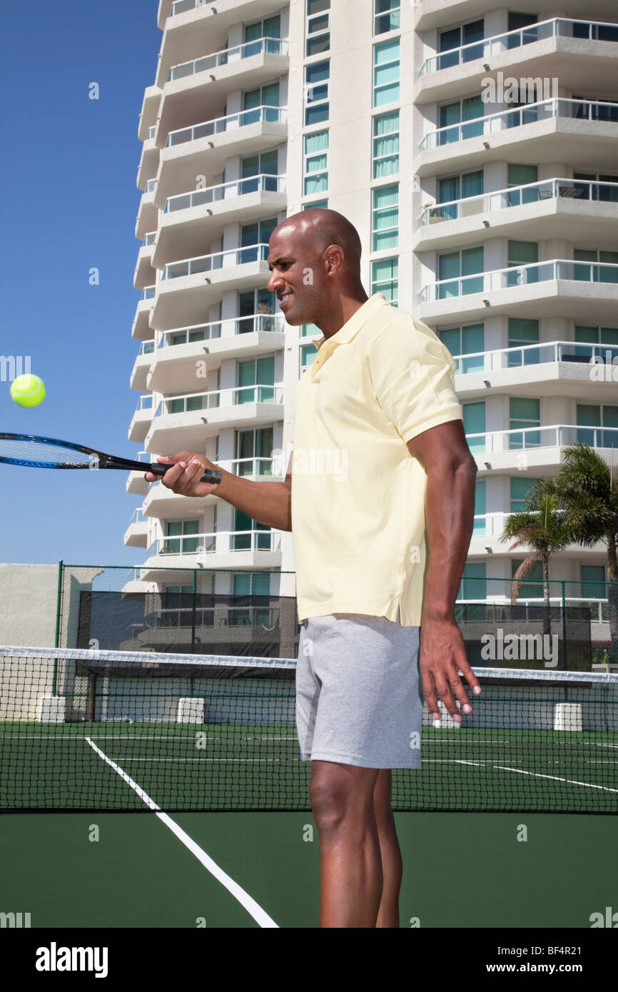 African man balancing tennis ball on racket Stock Photo - Alamy