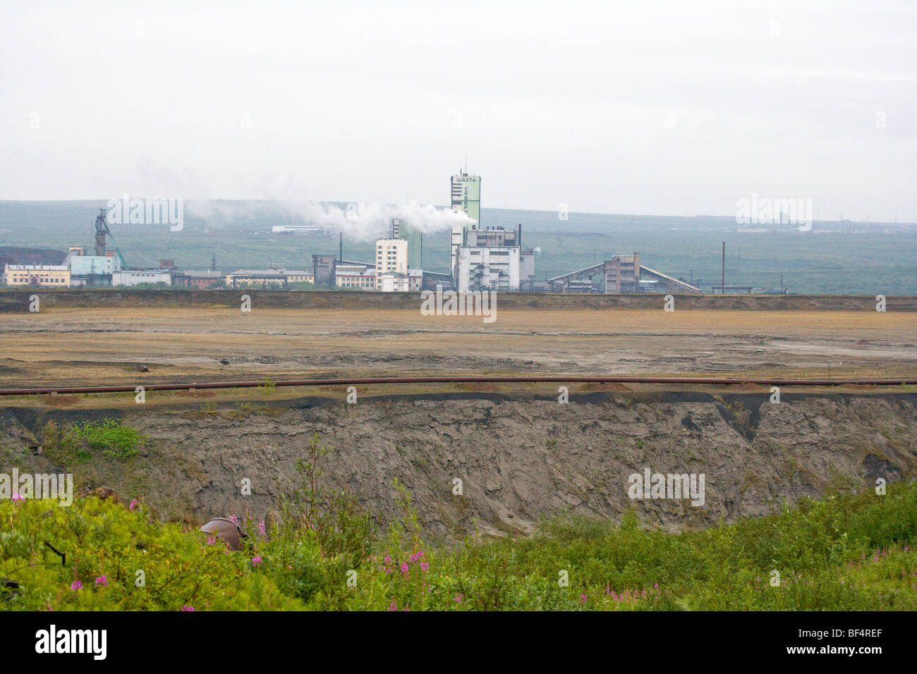 Industrial coal mining landscape with slag heap and smoke stacks ...