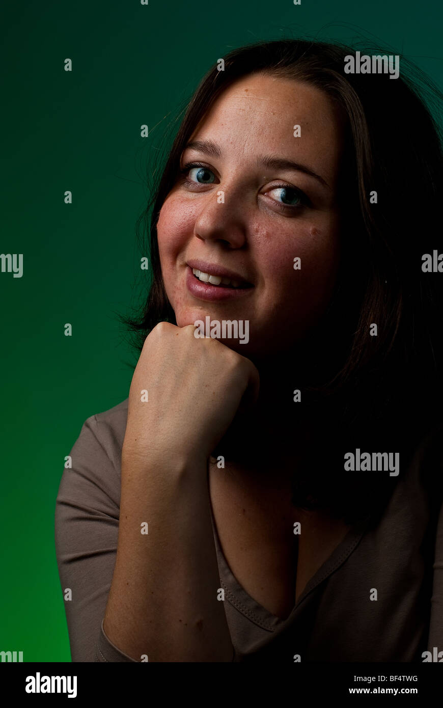 young woman smiling headshot on a green background Stock Photo - Alamy