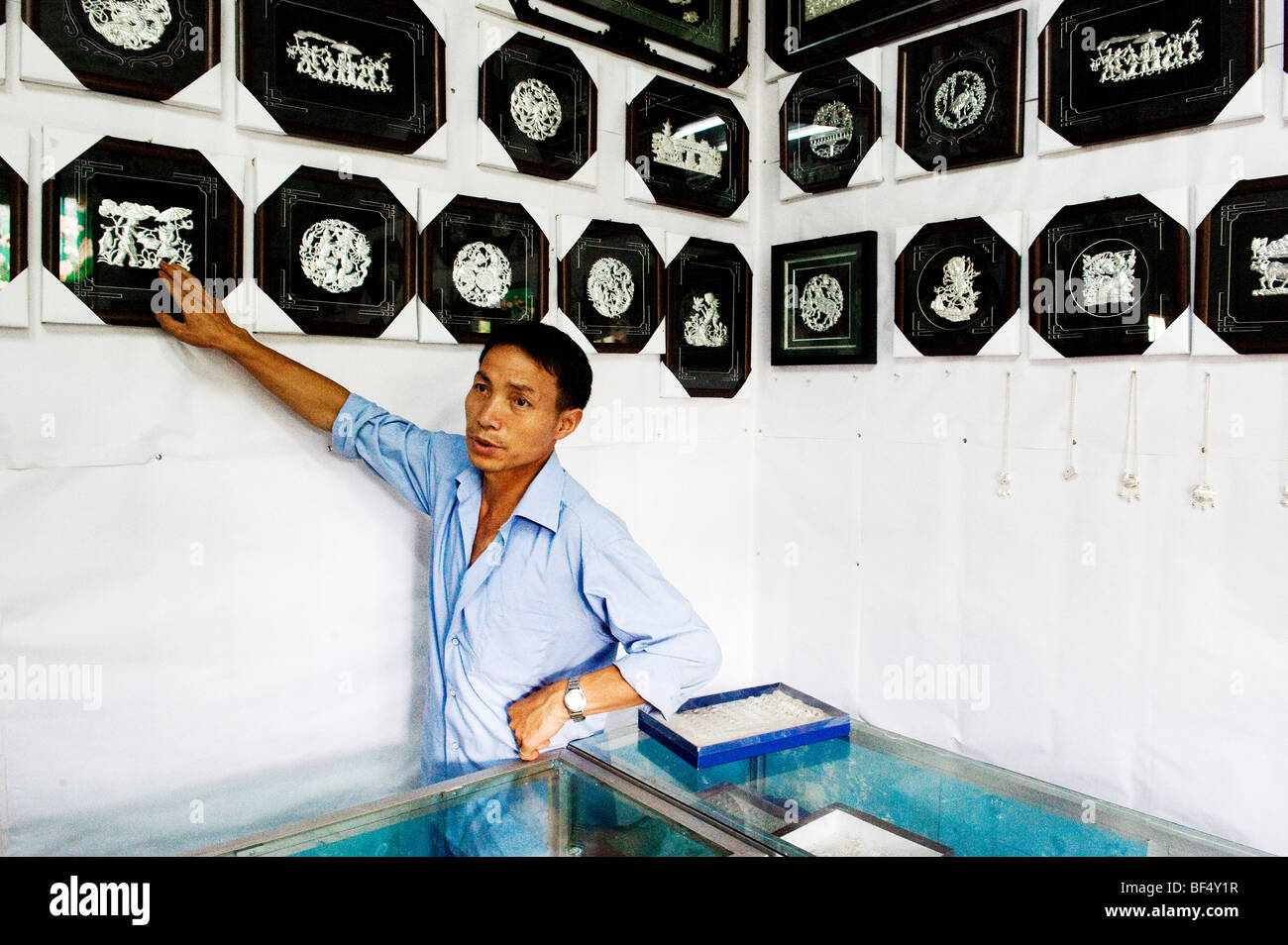 Miao silversmith displaying silver carvings, Taijiang, Guizhou Province ...
