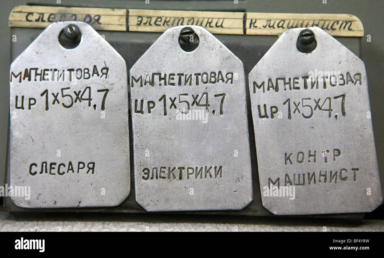 Three silver tags with Russian words and numerals in abandoned ...