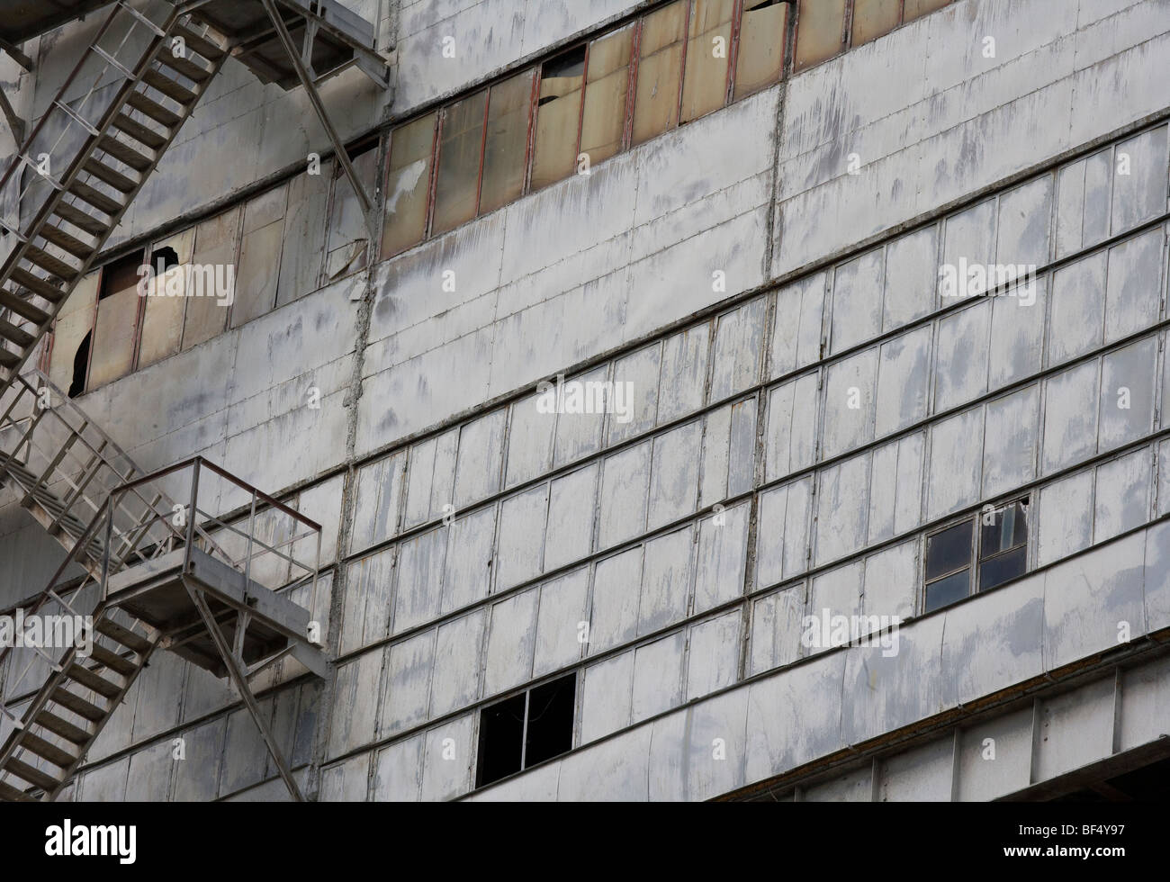Factory building with facade of cladding and fire escape staircase ...