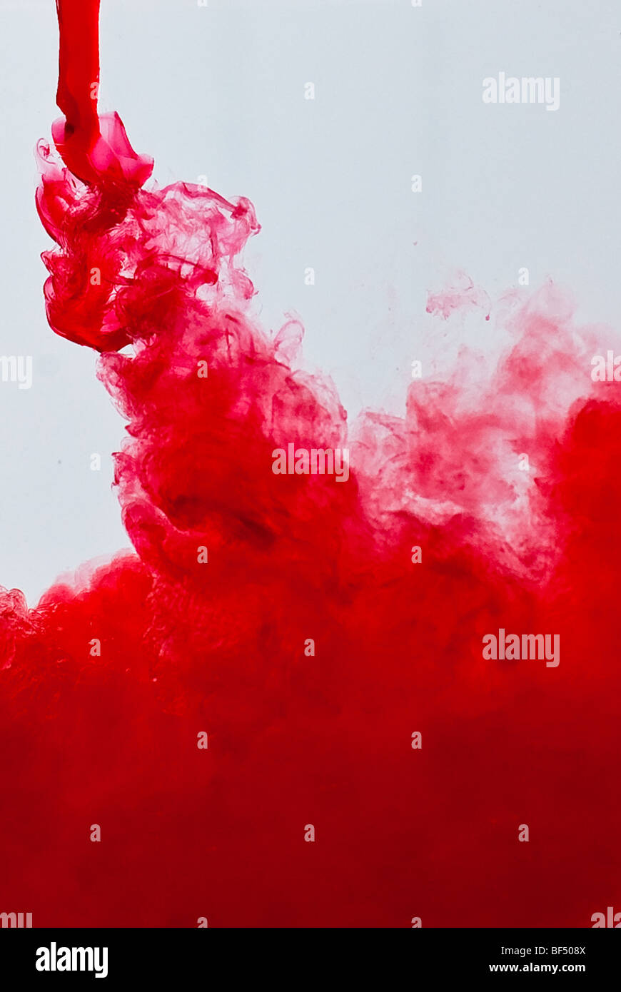 red smoke-like fluid poured into the water Stock Photo - Alamy