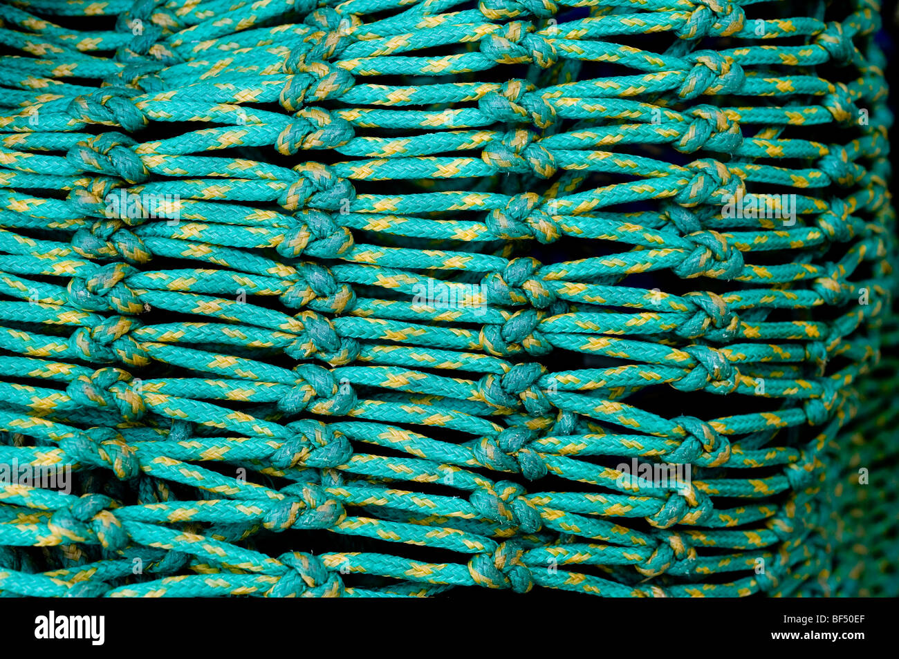 Industrial commercial green coloured fishing nets line the quayside in ...