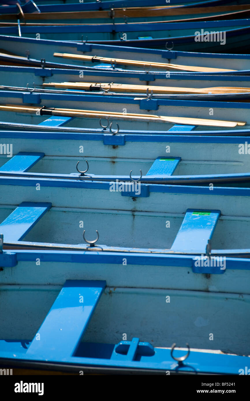 Blue boats floating next to each-other in a line with oars Stock Photo ...