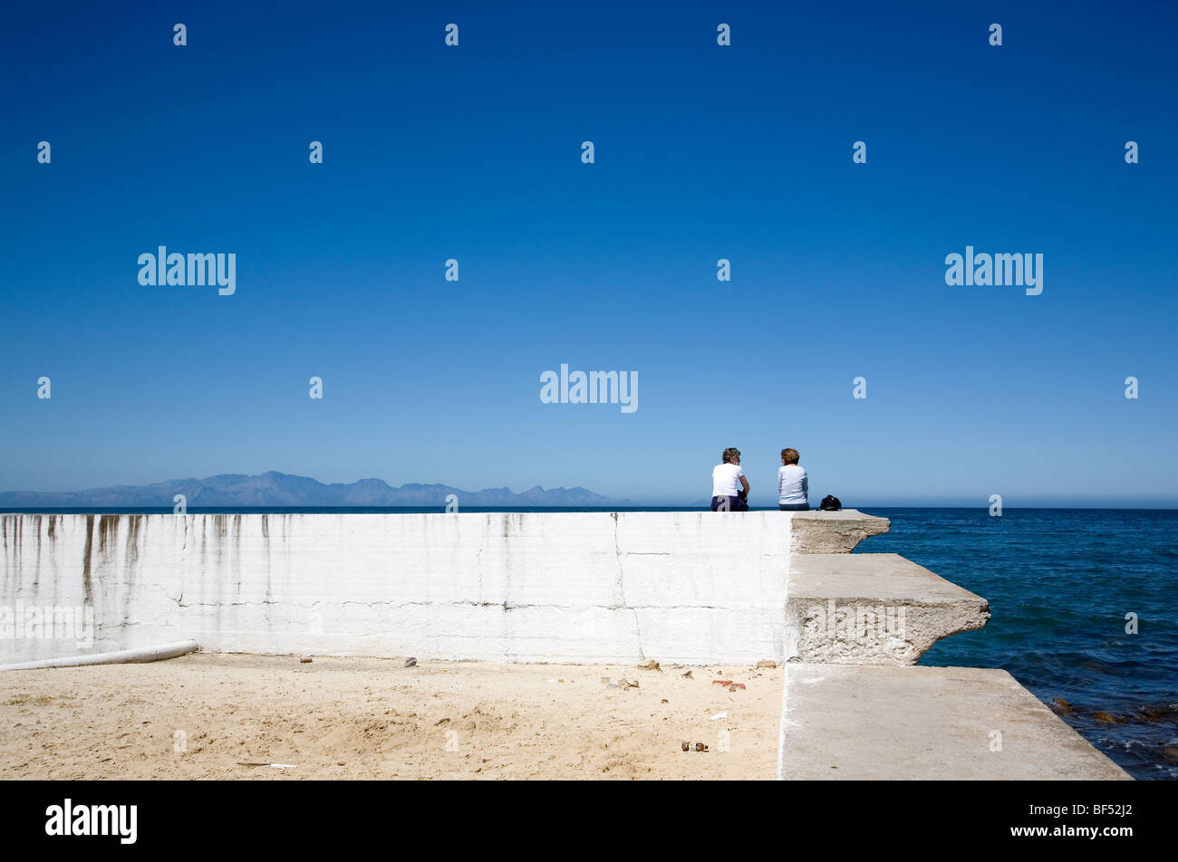 Two women chatting on Sea wall Stock Photo - Alamy