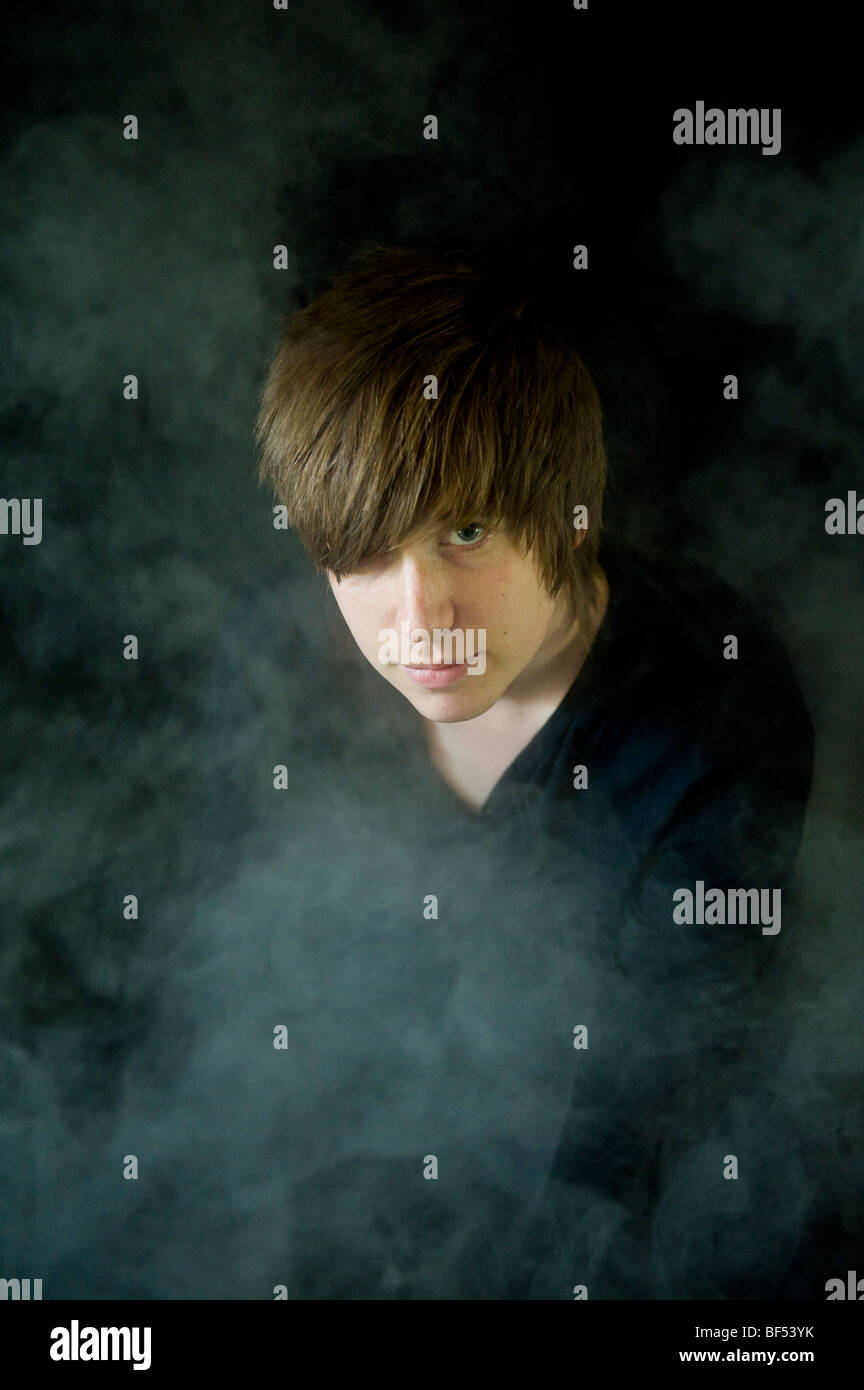 A young man poses in a smoky atmosphere Stock Photo - Alamy
