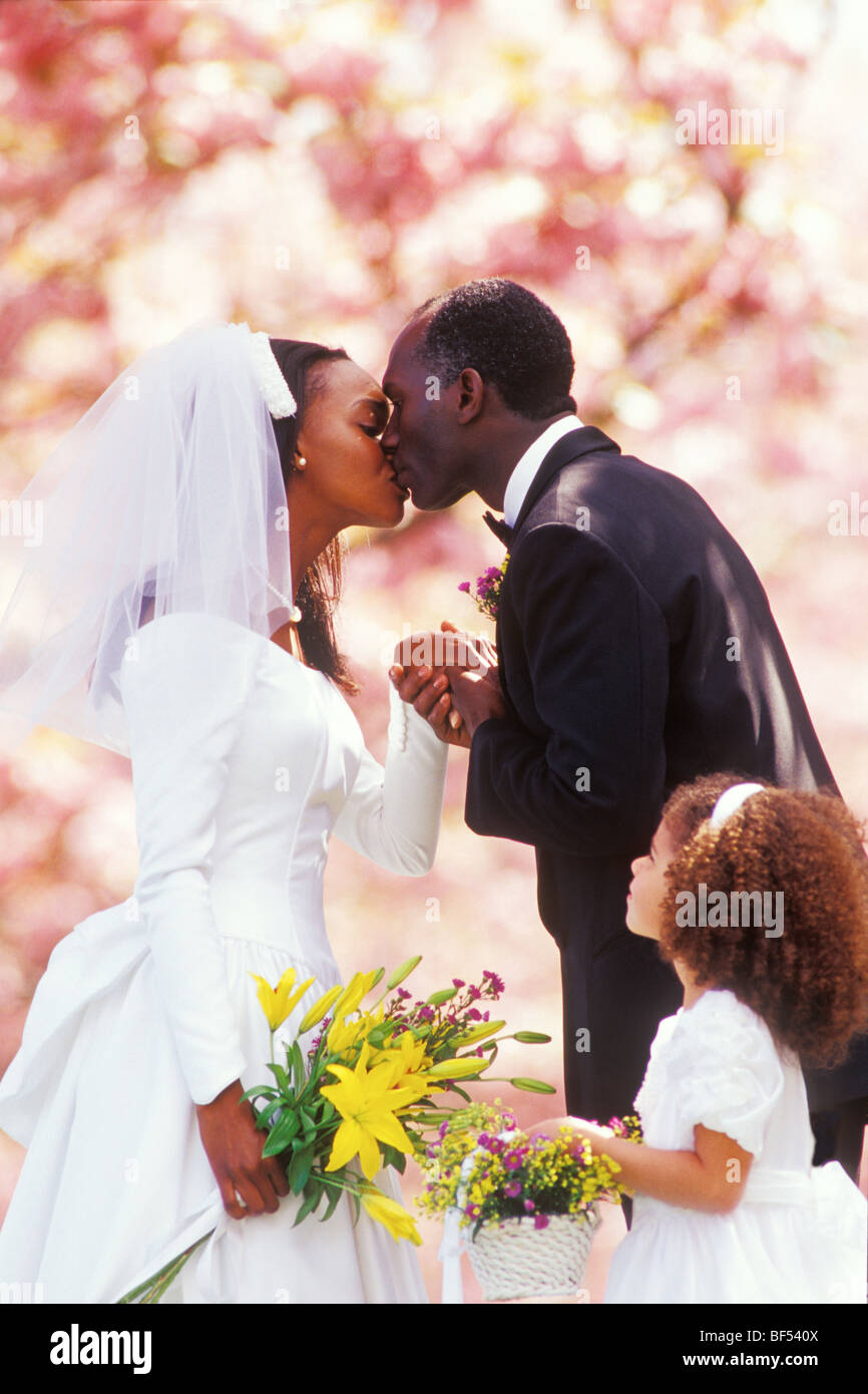 A bride and groom kiss during their wedding beneath a canopy of cherry ...