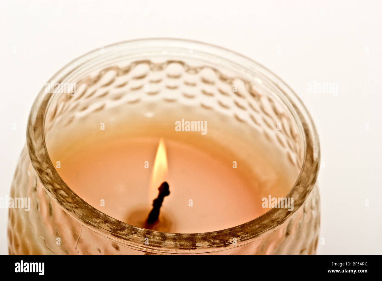 Lit candle in a glass container Stock Photo - Alamy