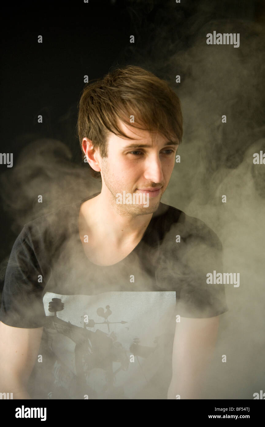 A young man poses in a smoky atmosphere Stock Photo - Alamy
