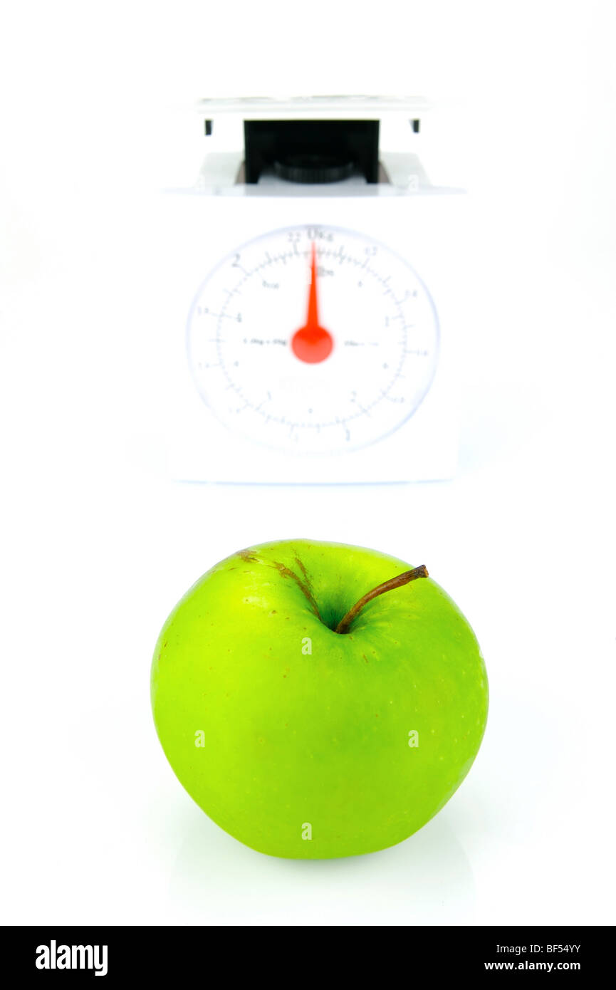 An apple and a set of scales isolated against a white background Stock ...