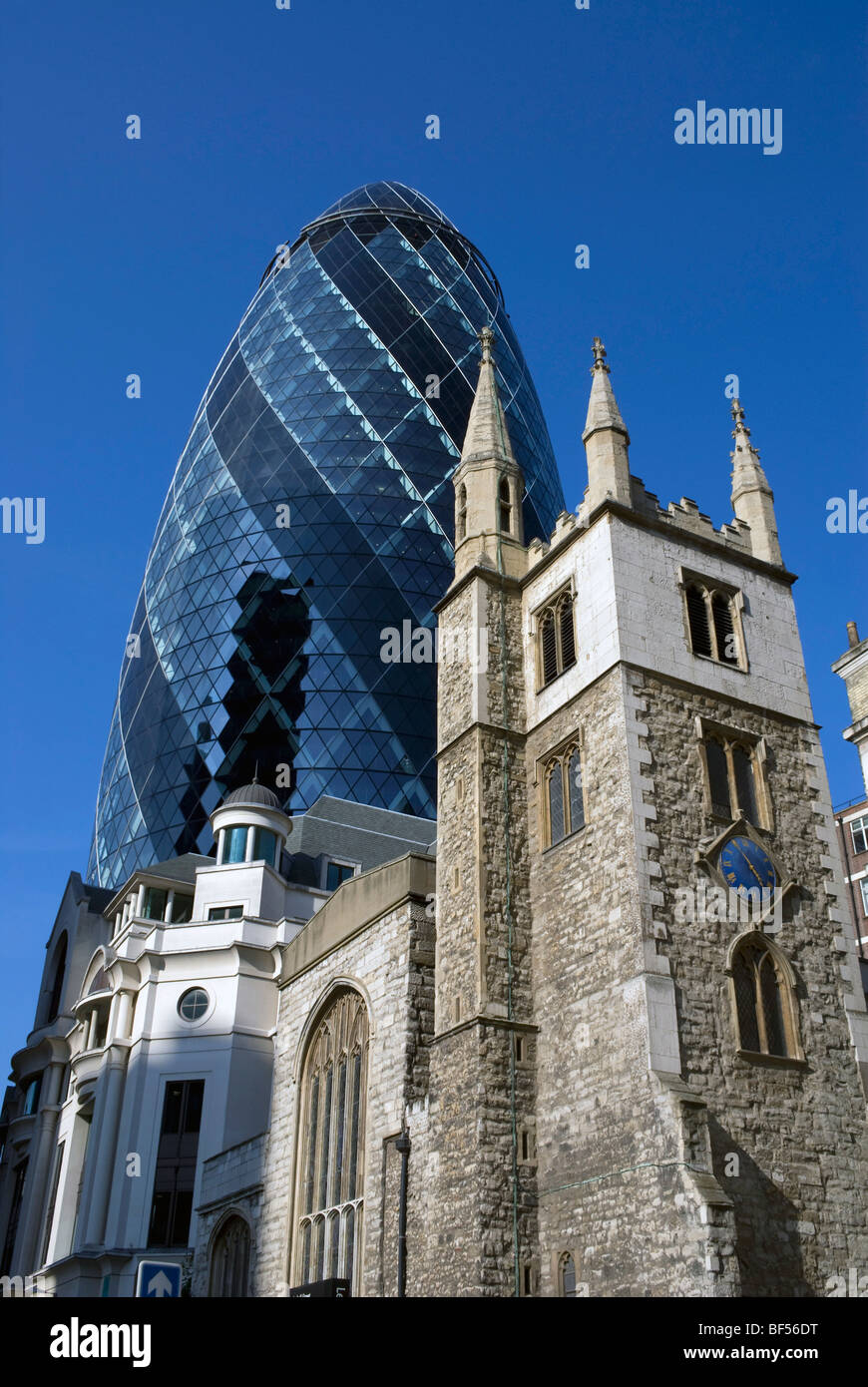 Traditional buildings in front of the Gherkin Building, London, England ...