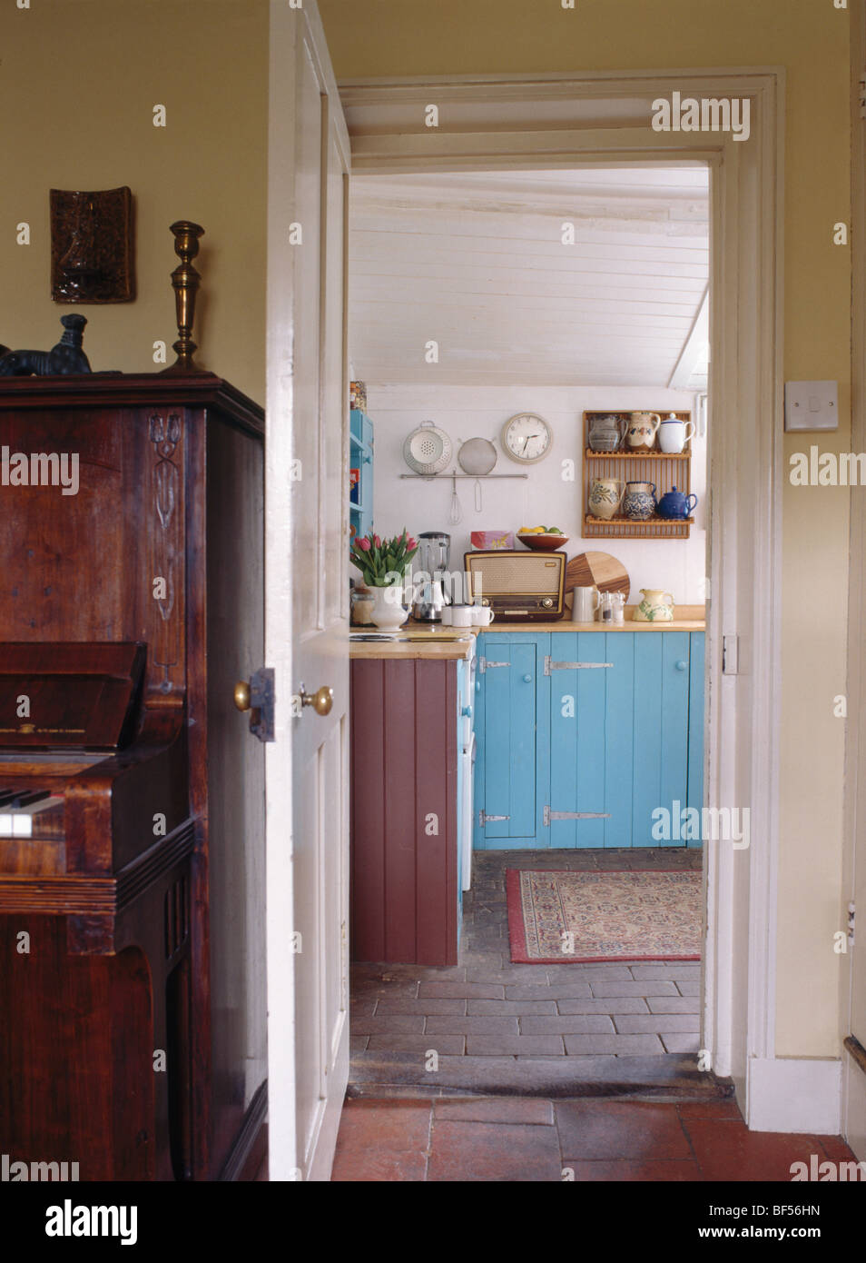 Door open to traditional country cottage kitchen with fitted blue unit ...