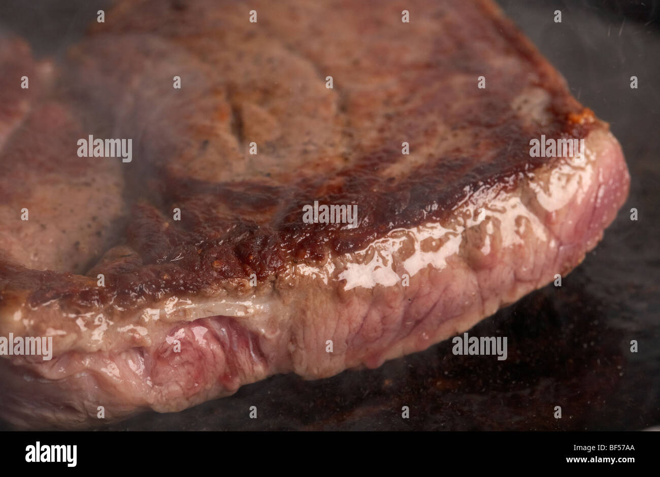 slice of chump steak from organic longhorn irish cows frying in a ...