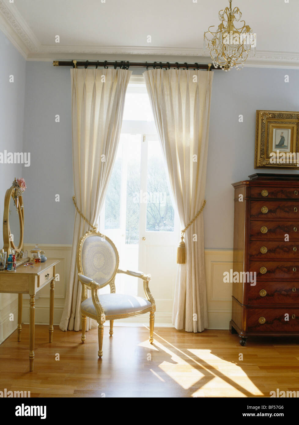 Louis IV-style chair in front of open French windows with cream ...