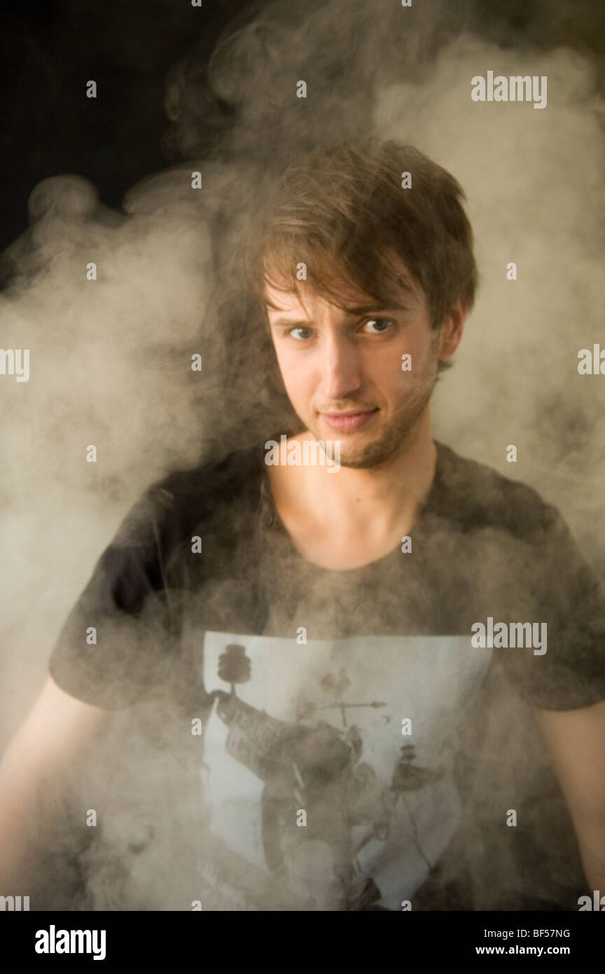 A young man poses in a smoky atmosphere Stock Photo - Alamy