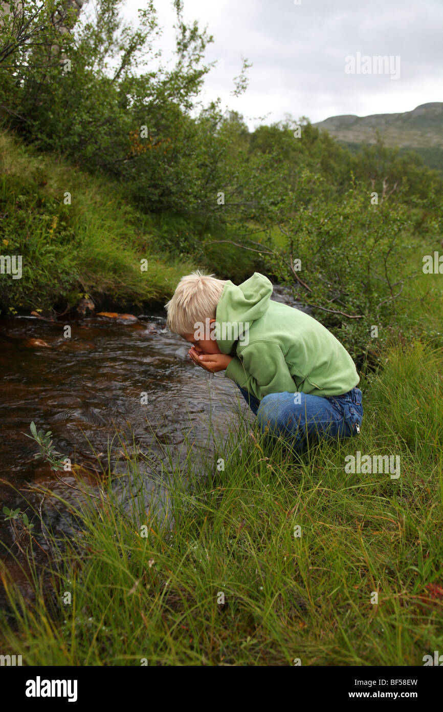 young boy drinking water from a stream Stock Photo - Alamy