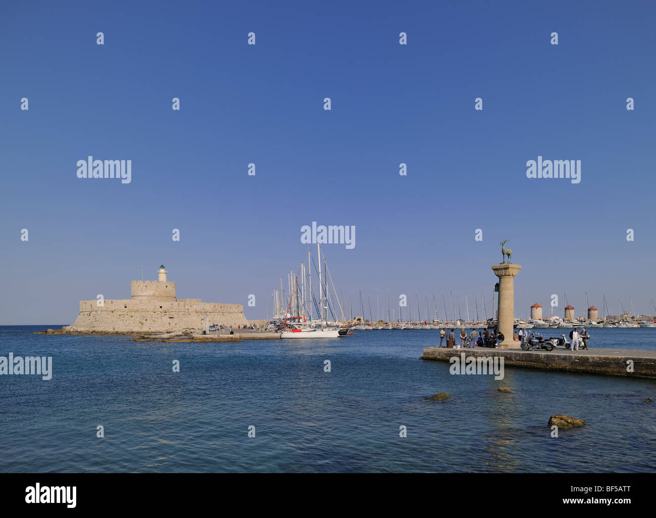 Entrance of the Mandraki harbour with the castle of Agios Nikolaos and ...