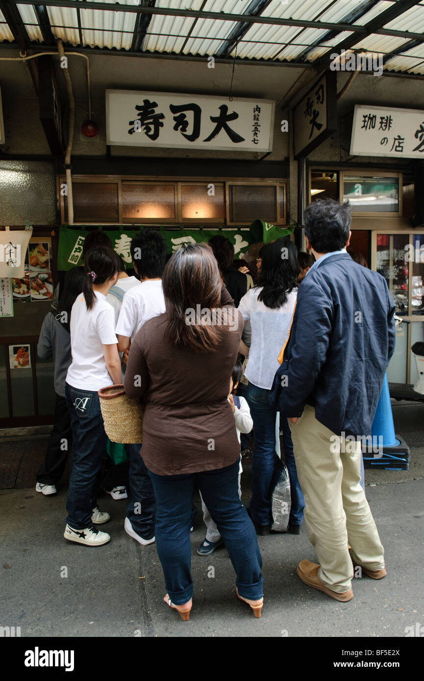 Tourist queuing to enter a sushi shop, Tsukiji fish market, Tokyo ...