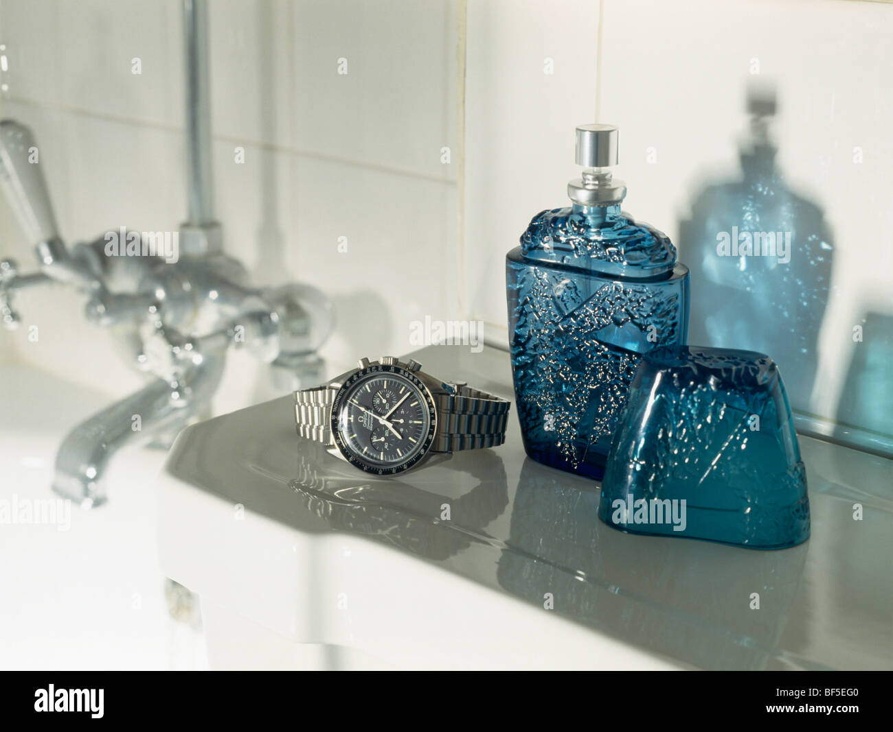 Close-up of man's wrist-watch and two blue pressed glass bottles Stock ...