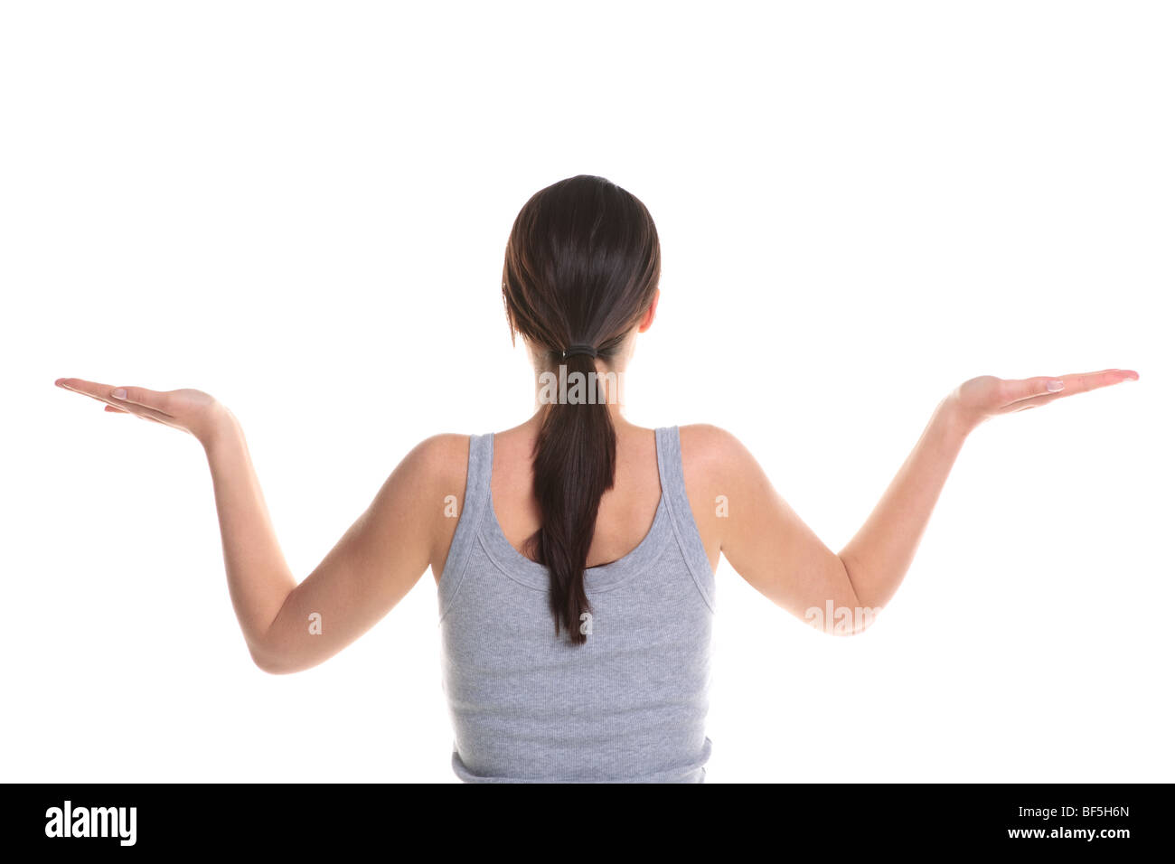 Rear view of a brunette woman doing yoga with her arms outstretched ...