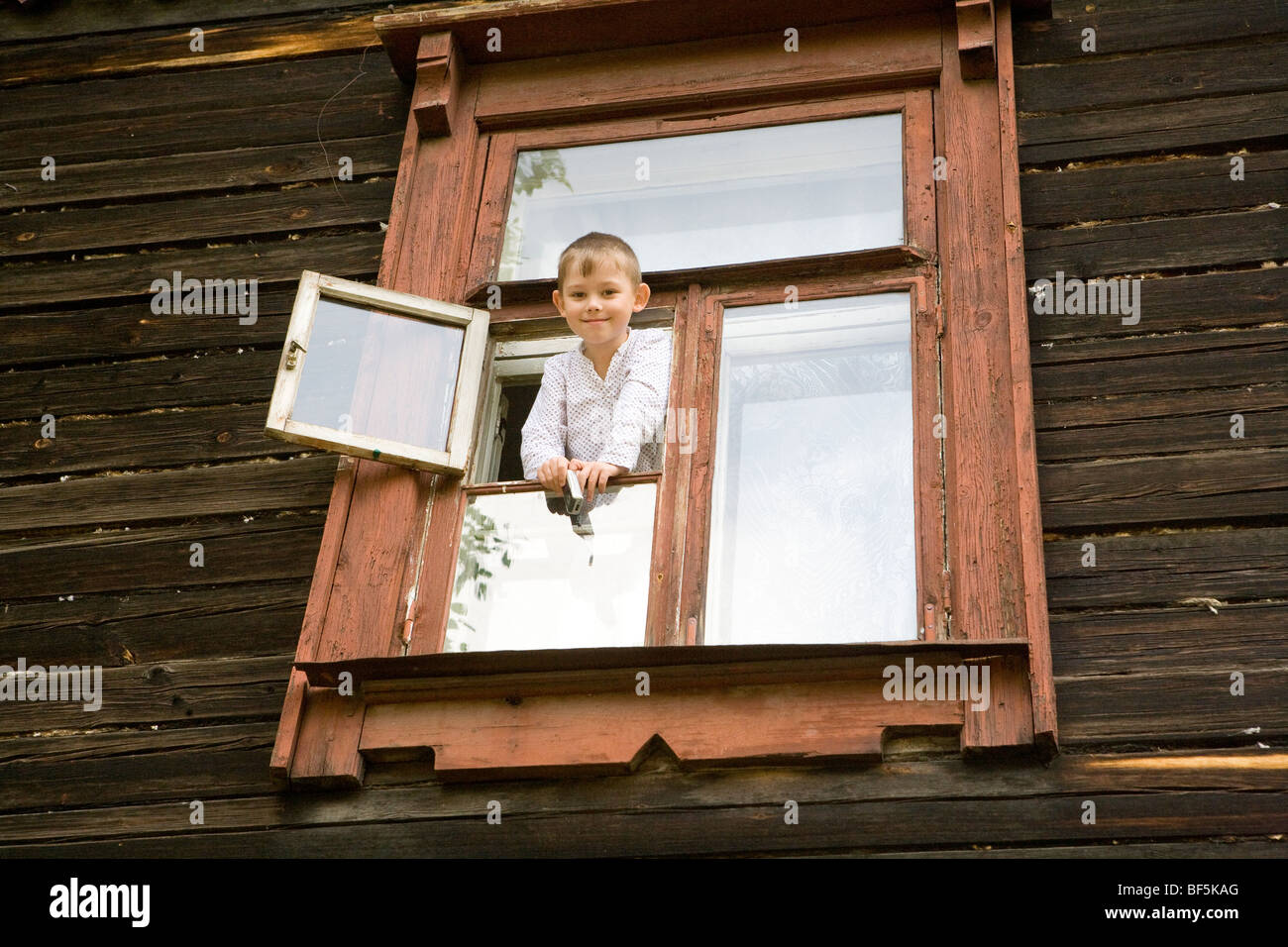 Boy leaning out of open window, Ural Mash, Yekaterinburg, Russia Stock ...