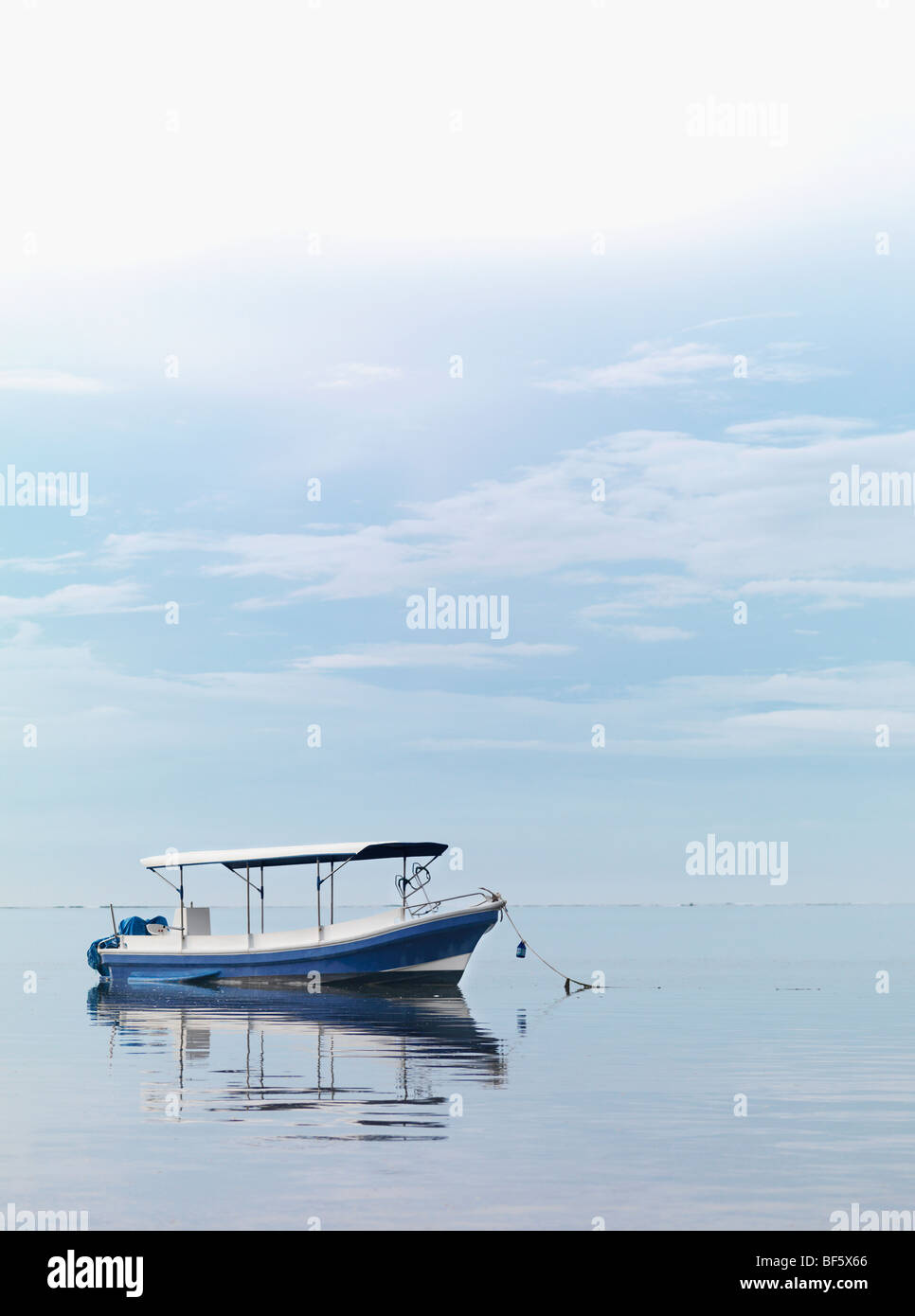 A passenger boat sits on a still ocean in the early morning Stock Photo ...