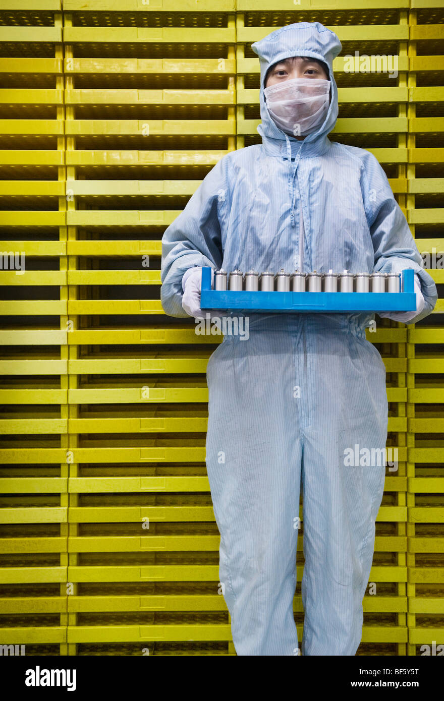 An employee of a battery company wearing a anti-contamination suit ...