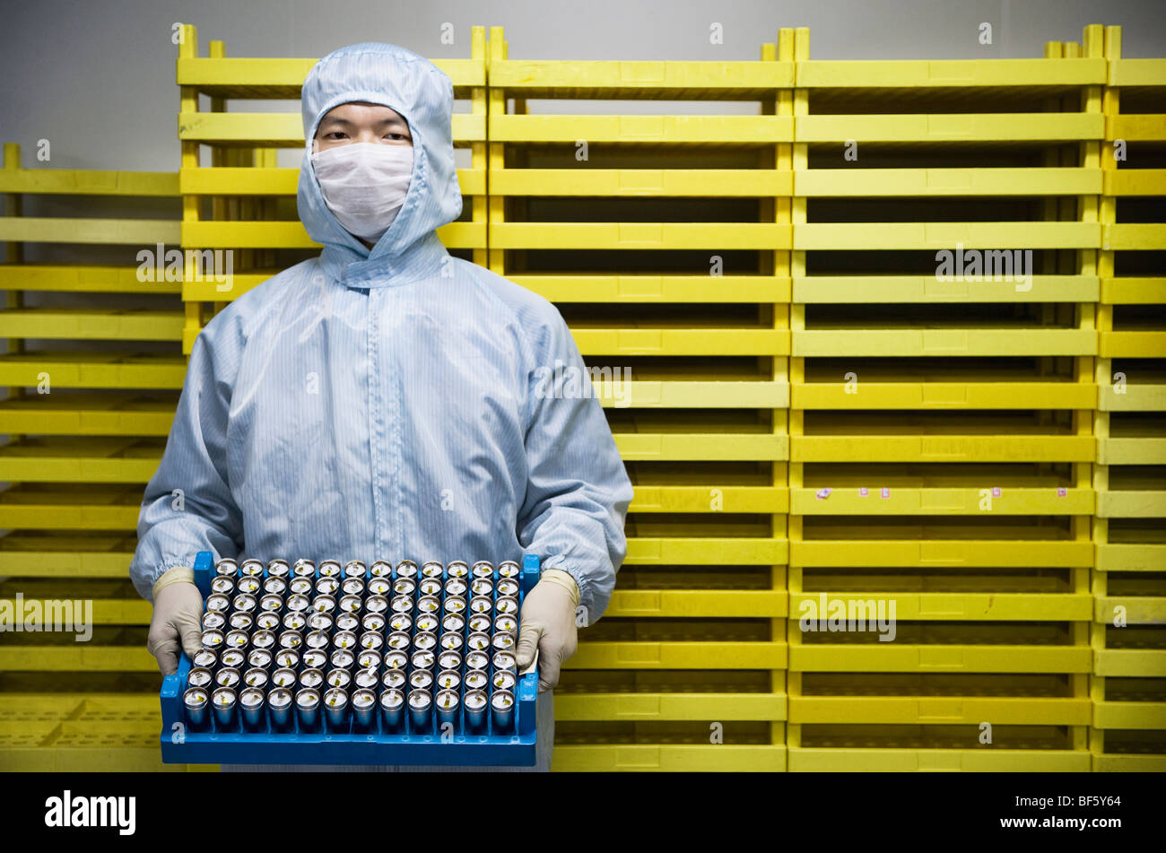 An employee of a battery company wearing a anti-contamination suit ...