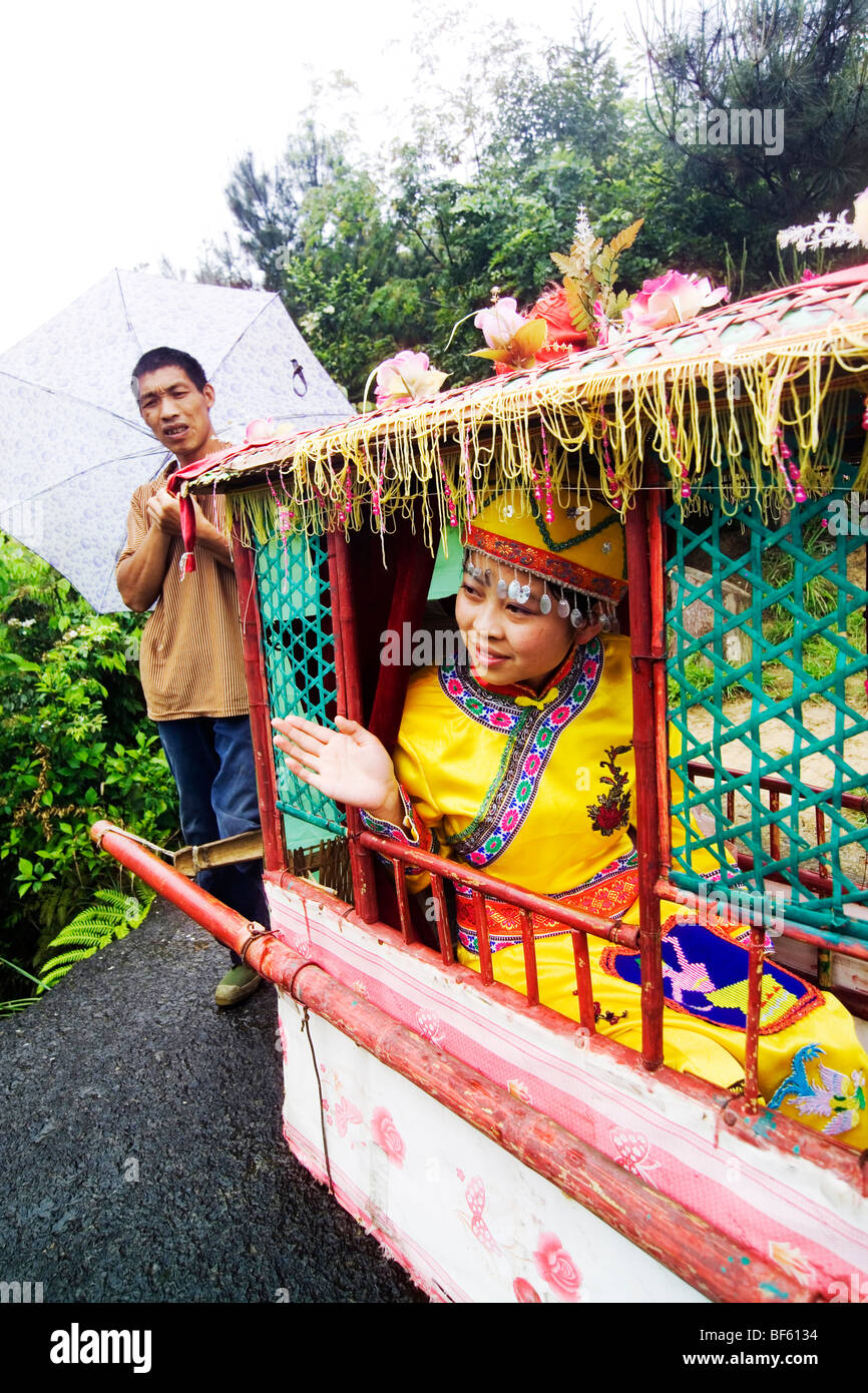 Tujia woman wearing traditional costume in sedan chair, Taiyanghexiang ...