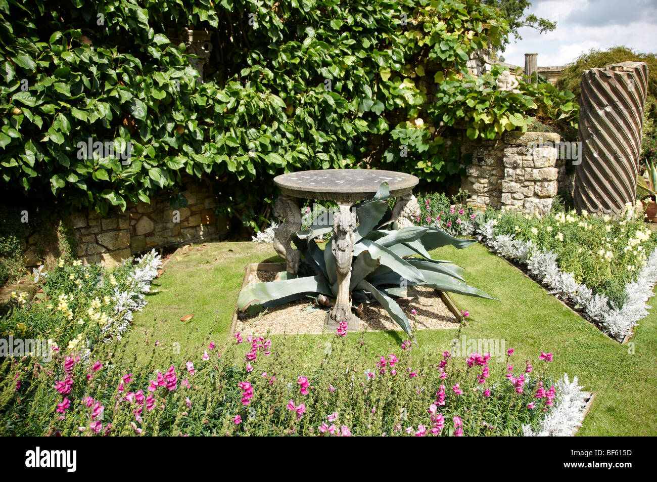 A stone table in a garden with a wall in the background Stock Photo - Alamy