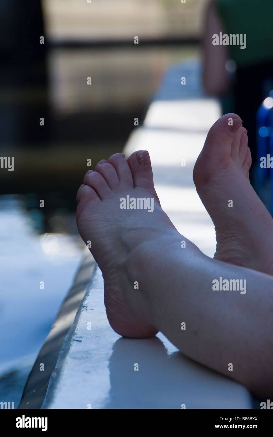 tired (female) feet, having a rest from tight shoes on the side of a ...