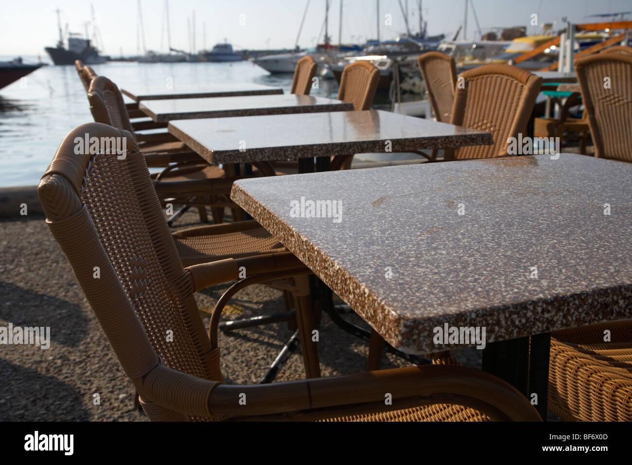 empty outdoor cafe tables next to paphos harbour marina republic of ...