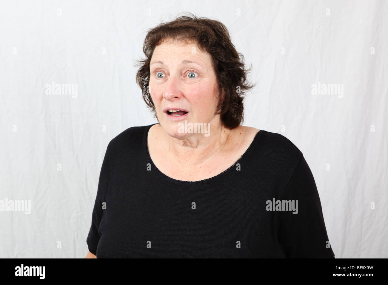 Shocked and startled middle aged woman with wide eyes looking surprised ...