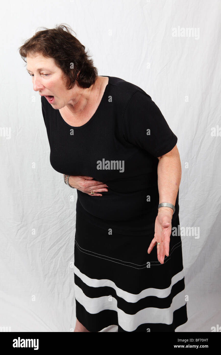 Middle aged 50s 60s woman holds stomach while retching throwing up ...