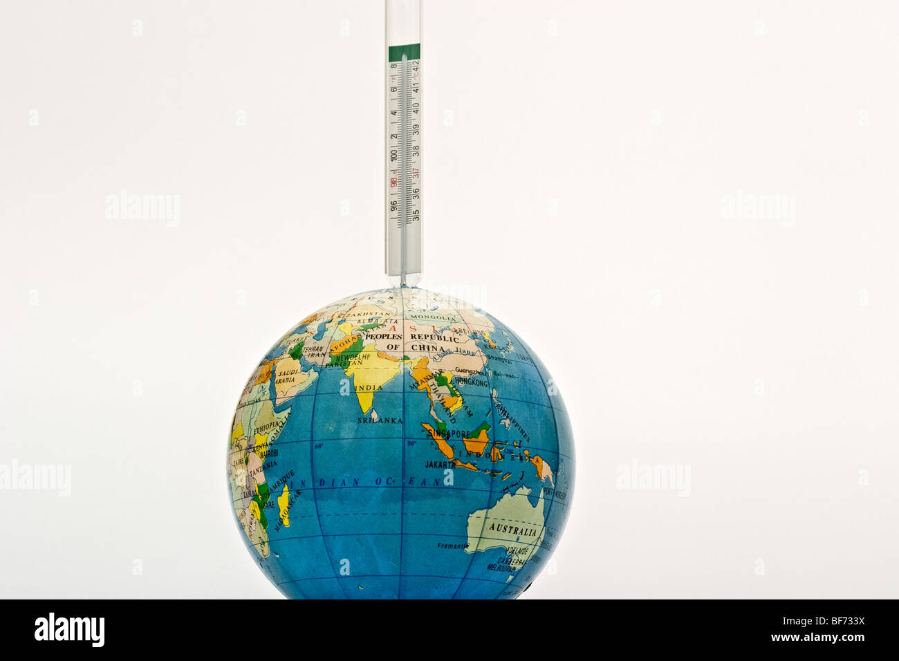 Thermometer at the top of a small globe of the world Stock Photo - Alamy