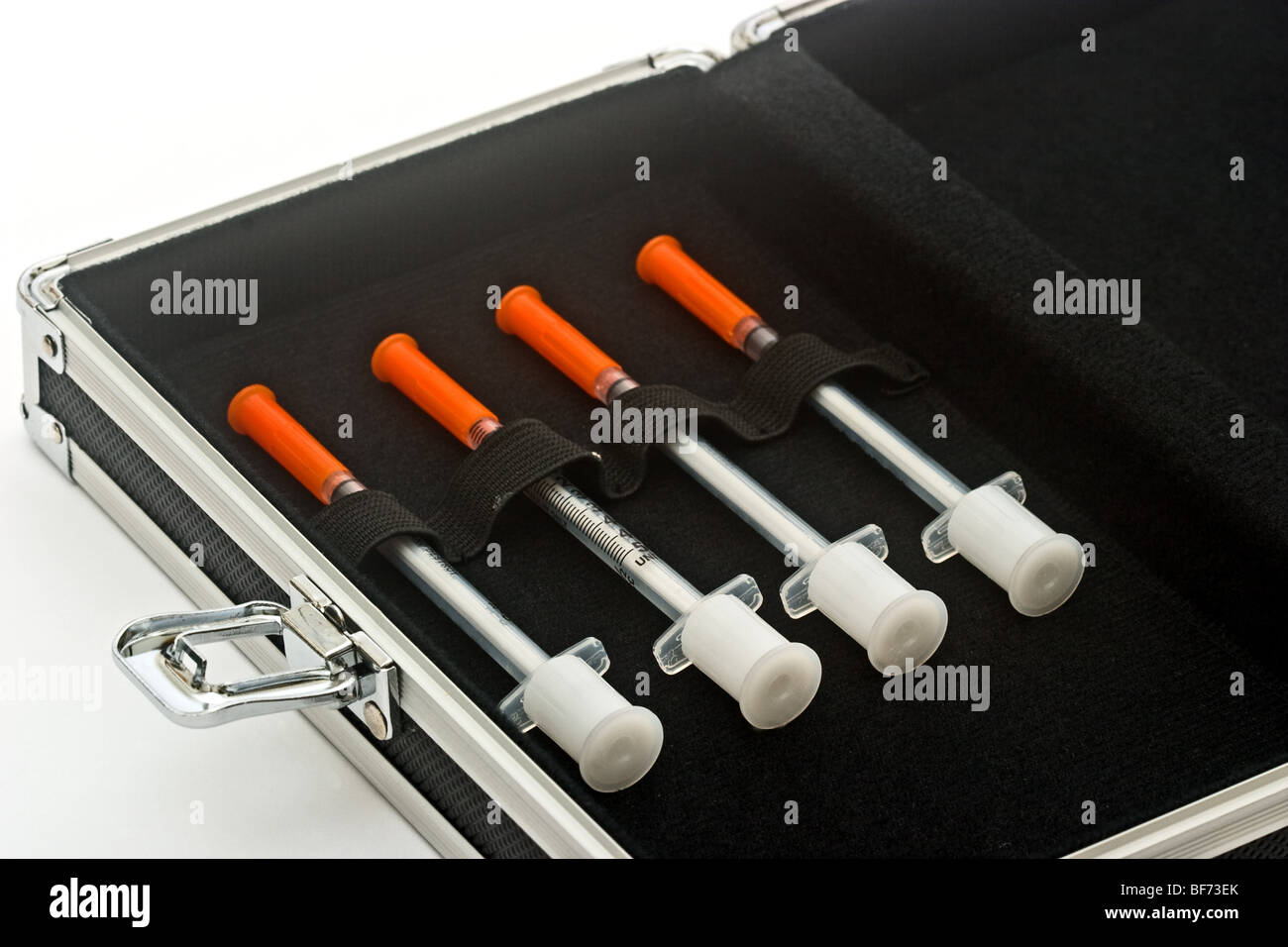 Row of syringes with orange covers in a black case Stock Photo - Alamy